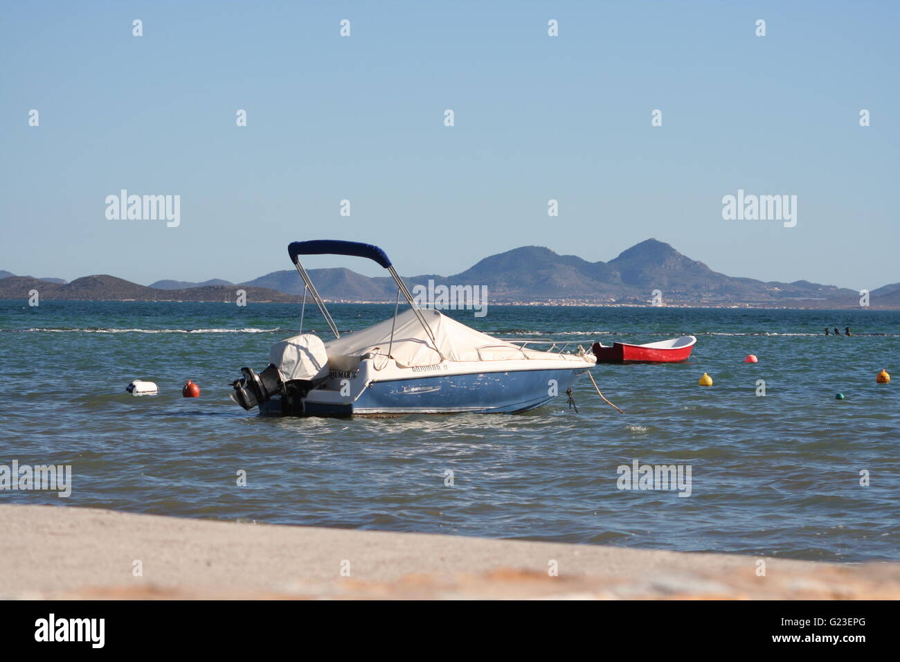 A boat in shallow waters at the beach Stock Photo - Alamy
