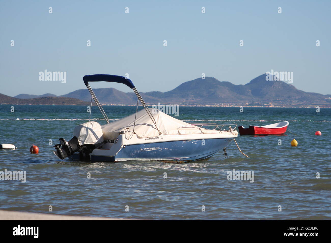A boat in shallow waters at the beach Stock Photo - Alamy
