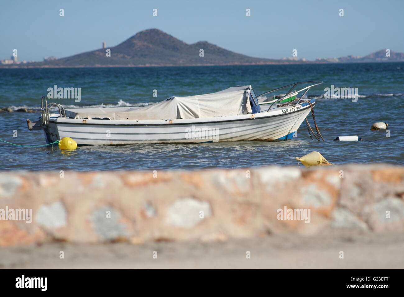 A boat in shallow waters at the beach Stock Photo - Alamy