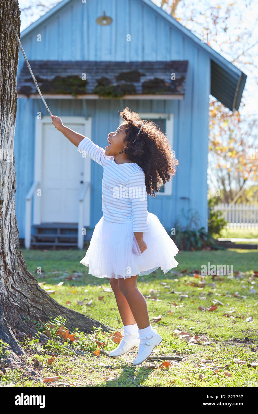 Kid toddler girl with branch stick playing outdoor park latin ethnicity ...