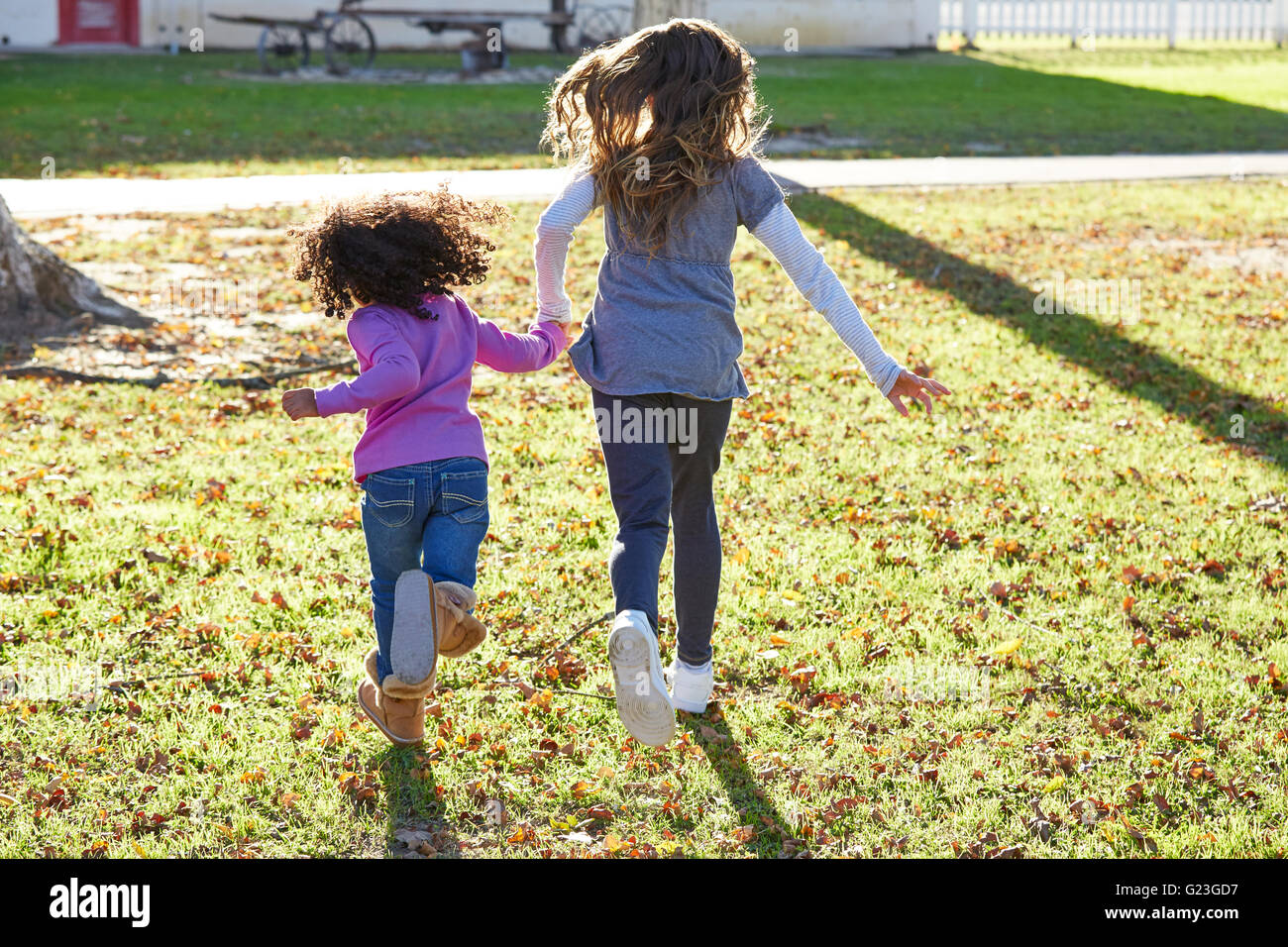 Multi ethnic kid girls playing running in park outdoor Stock Photo - Alamy