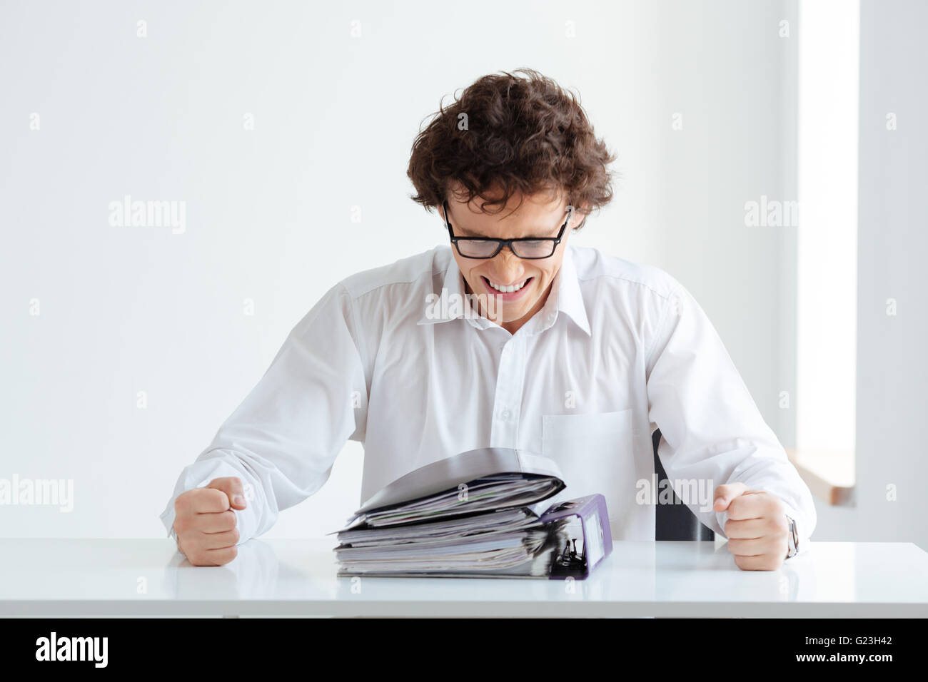 Angry businessman sitting at the table with papers in office Stock ...