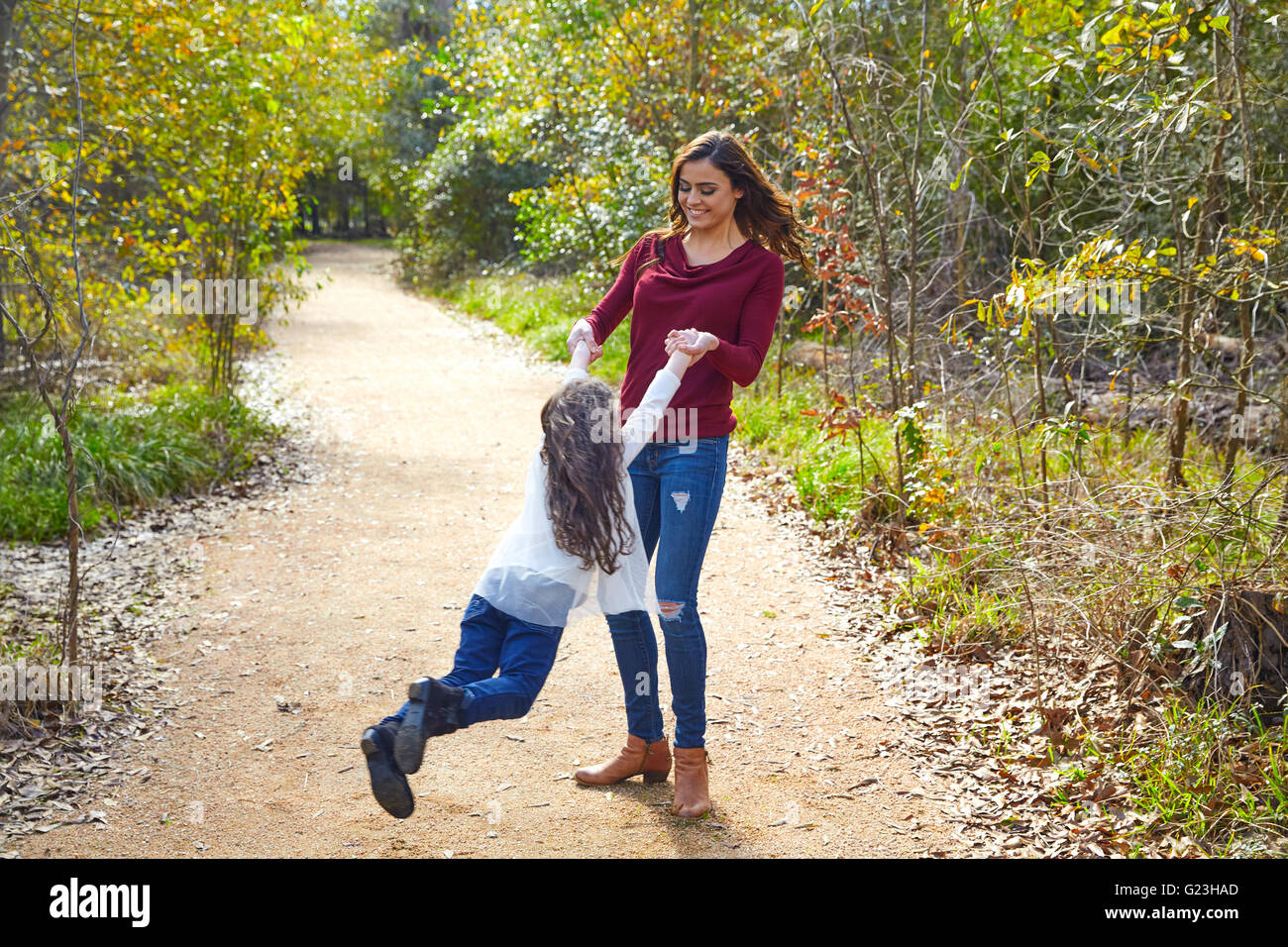 Mother and daughter being spun in circles at park having fun Stock ...