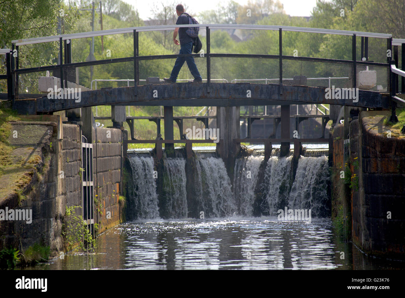 Man crossing a lock bridge on the Forth and Clyde canal, Glasgow ...