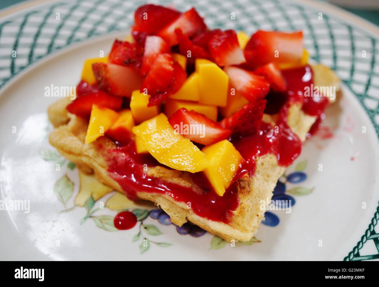 Freshly baked Belgian waffle with fresh fruit and berry coulis Stock ...