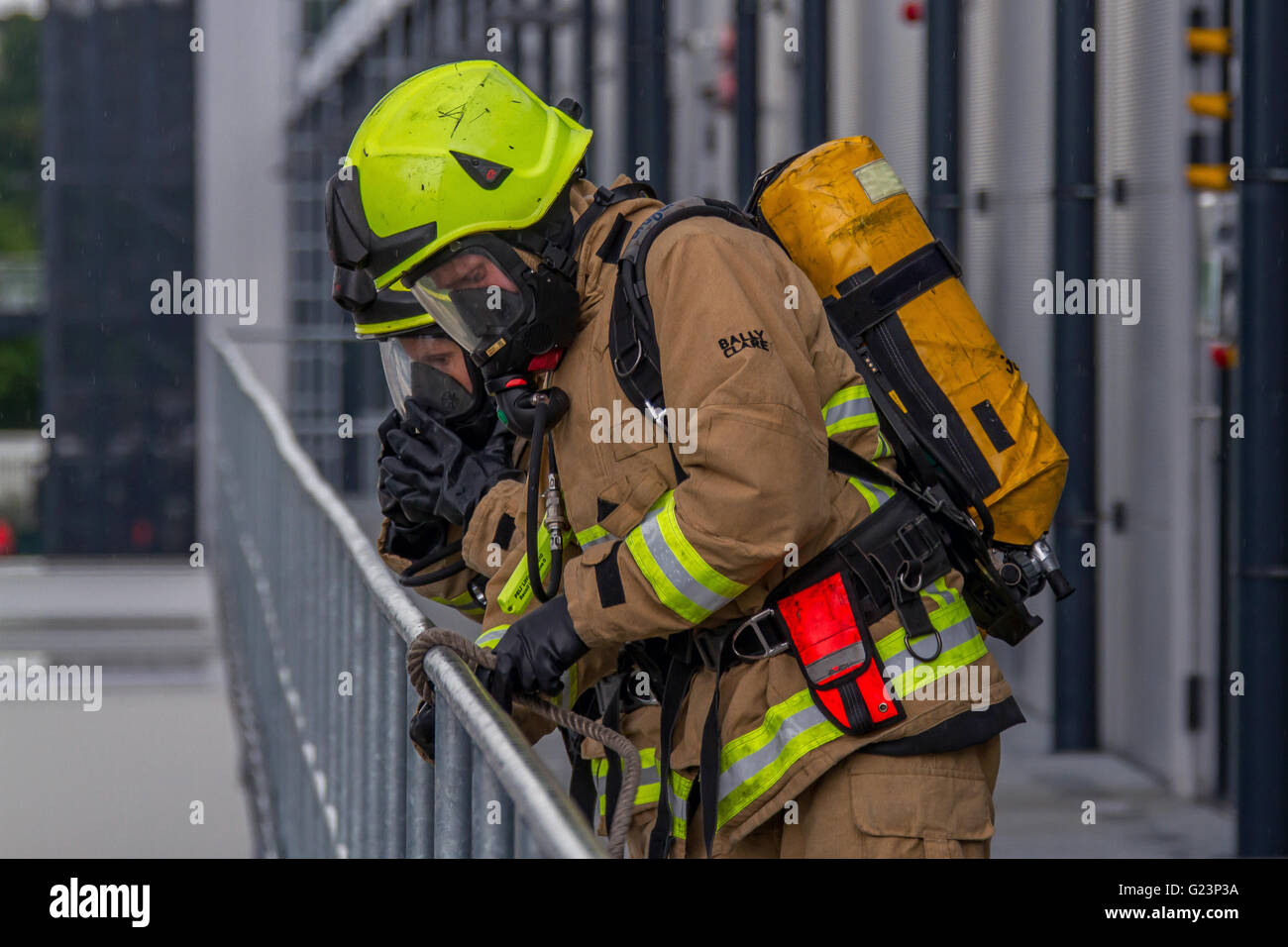 Firefighter wearing breathing apparatus ties a line from an external ...