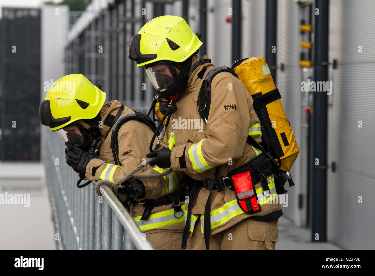 Firefighter wearing breathing apparatus ties a line from an external ...