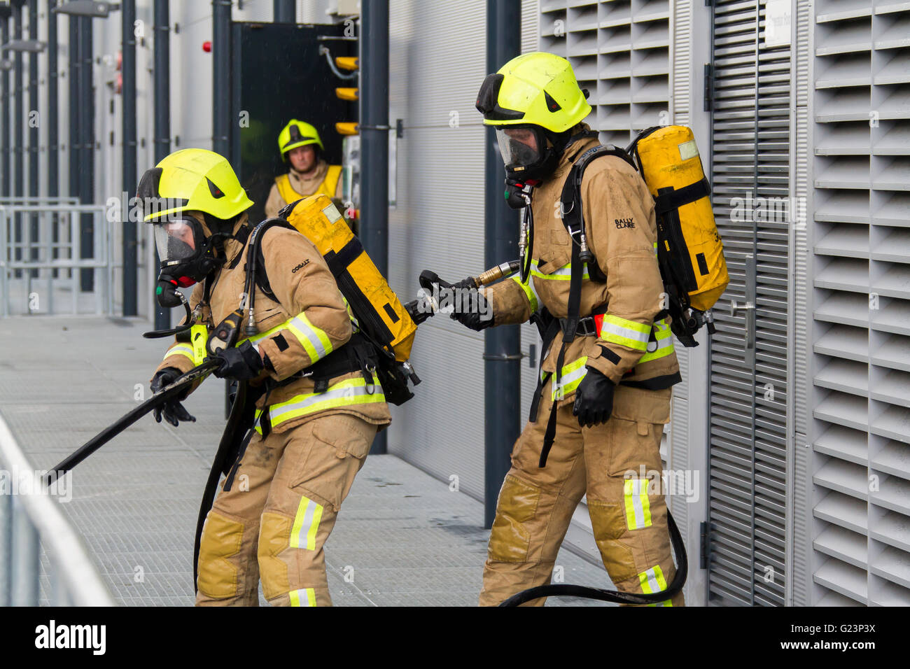 Firefighter wearing breathing apparatus drags a hosereel line on a ...