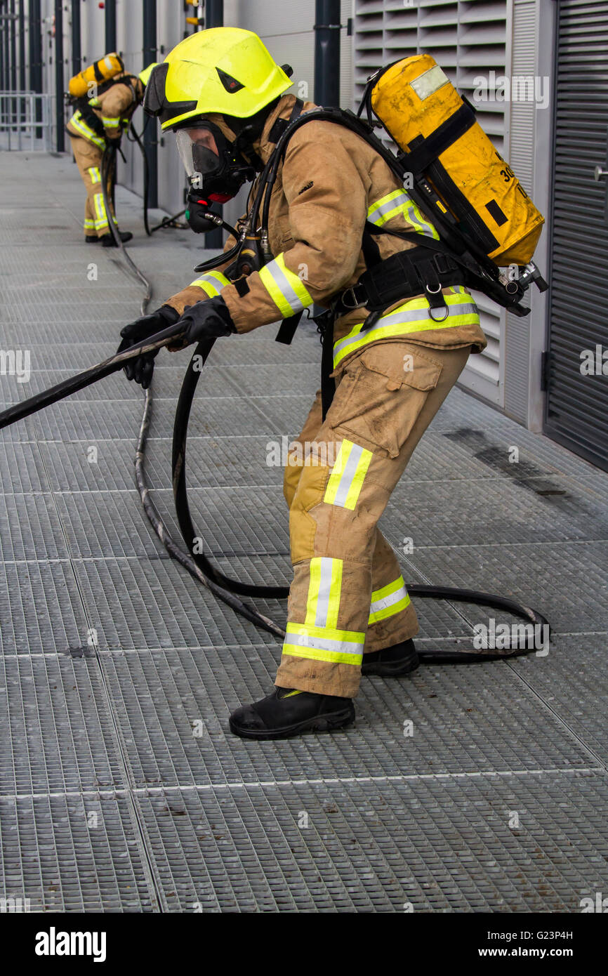 Firefighters Hose Wearing Breathing Apparatus High Resolution Stock ...
