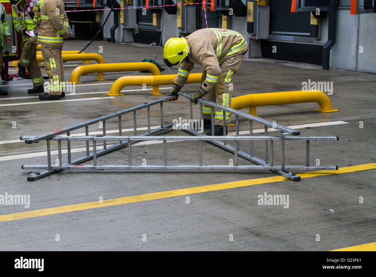 Fire fighters constructing a a dam using a salvage sheet and triple ...