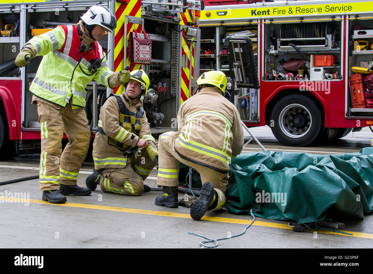 Fire fighters constructing a a dam using a salvage sheet and triple ...