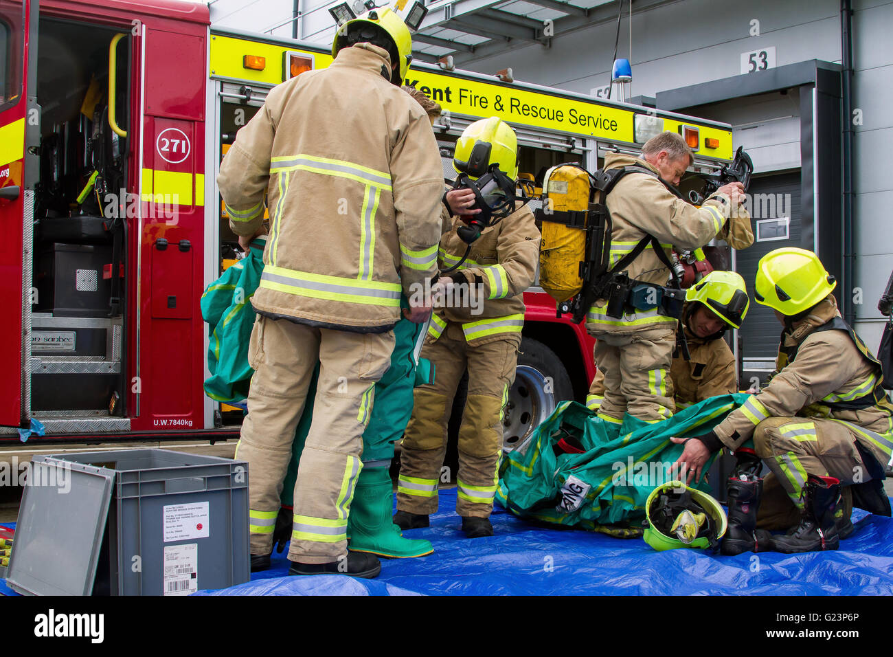 Firefighters assist colleague don Gas Tight Suit during a chemical ...