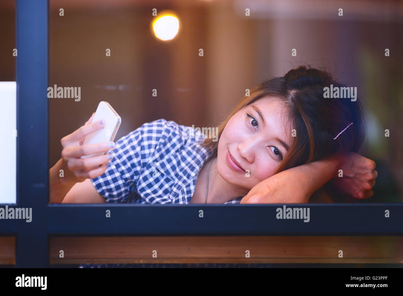 asia smile woman sitting at bar table and texting with her mobile ...