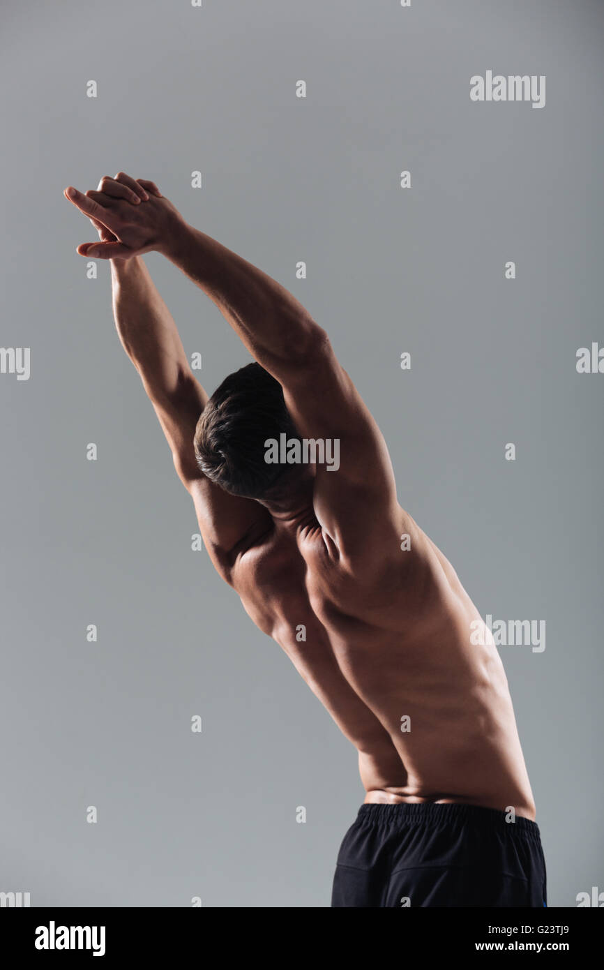 Rear view portrait of a fitness man doing stretching exercises over ...