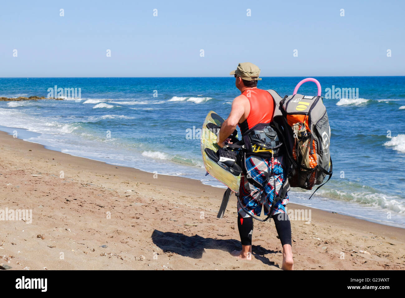 Kitesurfer carrying heavy gear at mediterranean sea kitesurfing ...