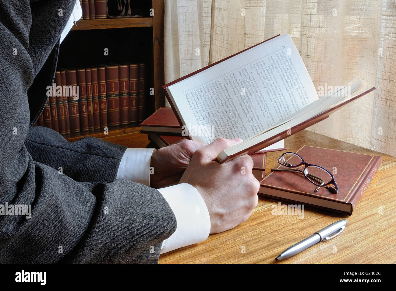 man reading a book built half on the table with interesting Stock Photo ...