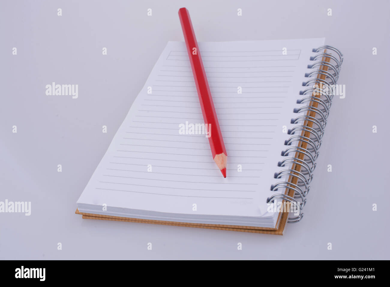 color pencil on a notebook on a white background Stock Photo - Alamy