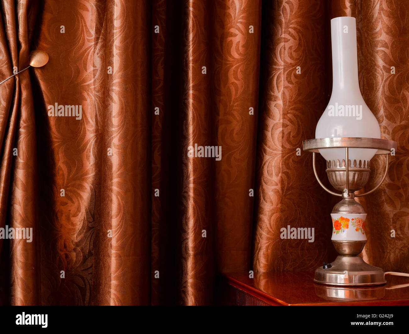 Old lamp on a furniture with velvet curtain in background Stock Photo ...