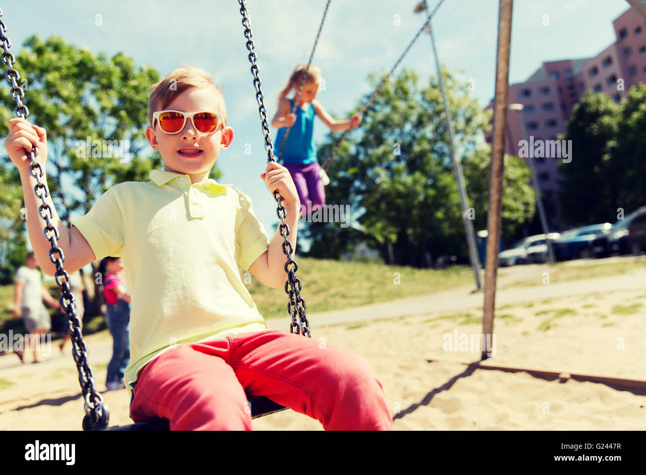 two happy kids swinging on swing at playground Stock Photo - Alamy