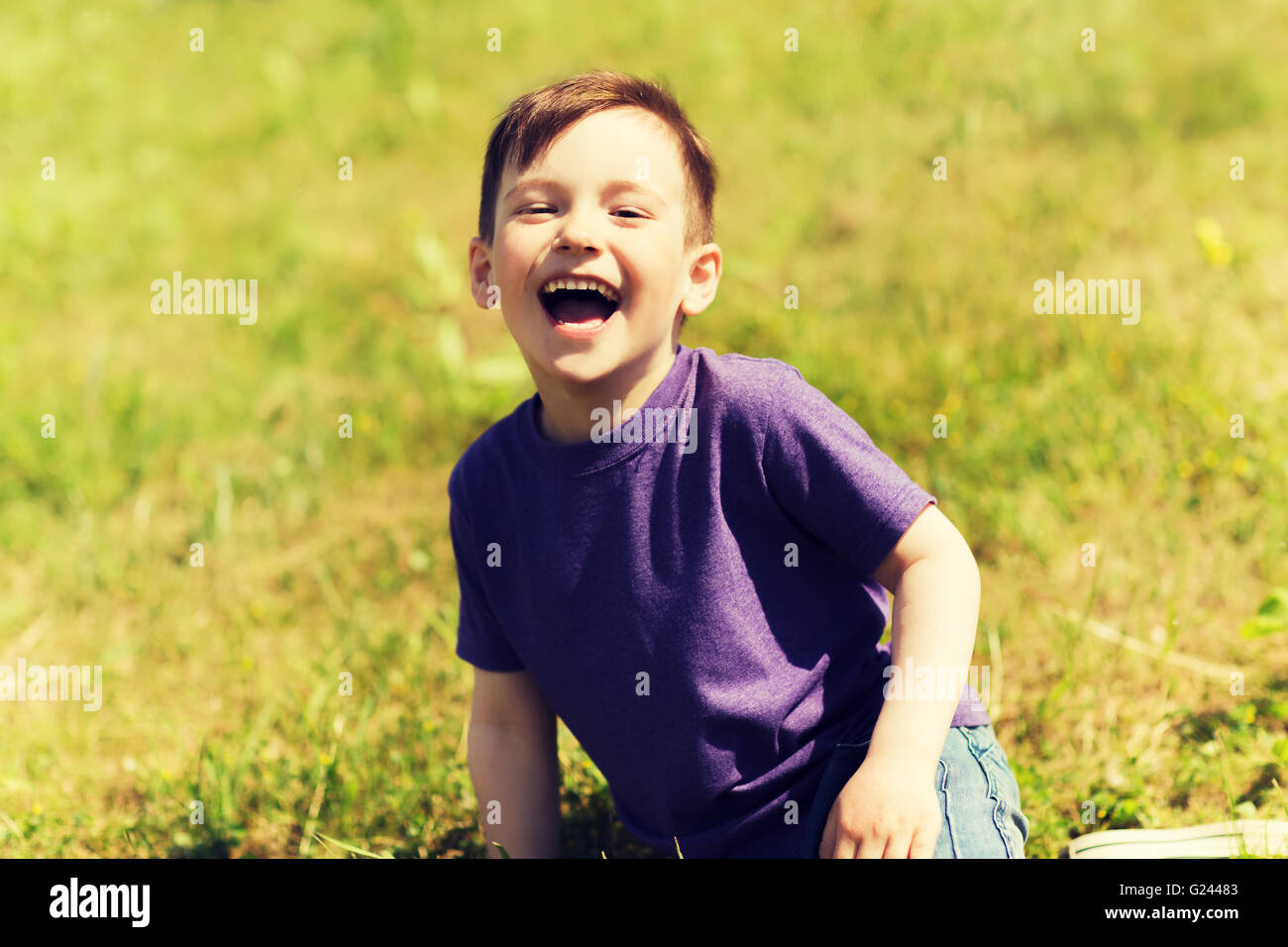 happy little boy sitting on grass outdoors Stock Photo - Alamy