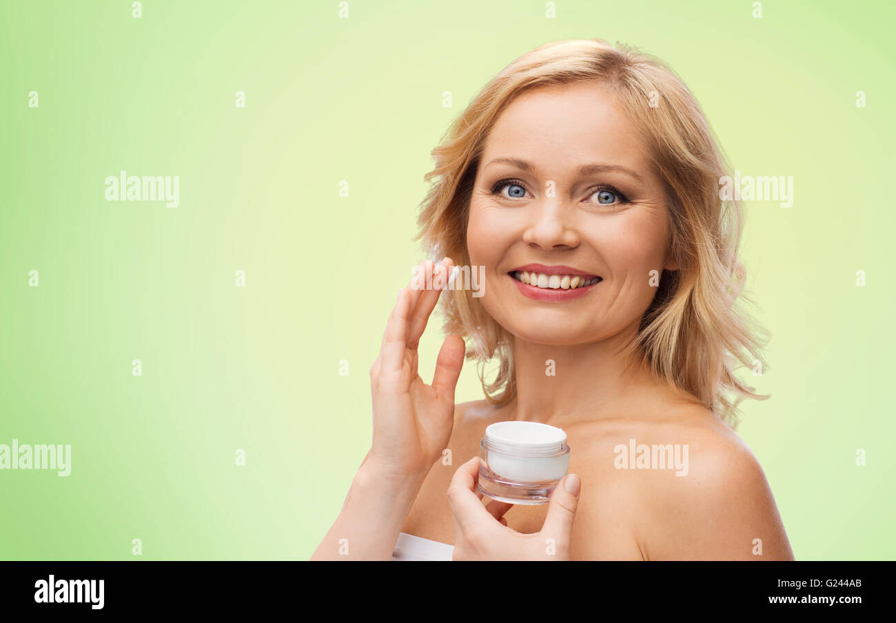 happy woman applying cream to her face Stock Photo - Alamy