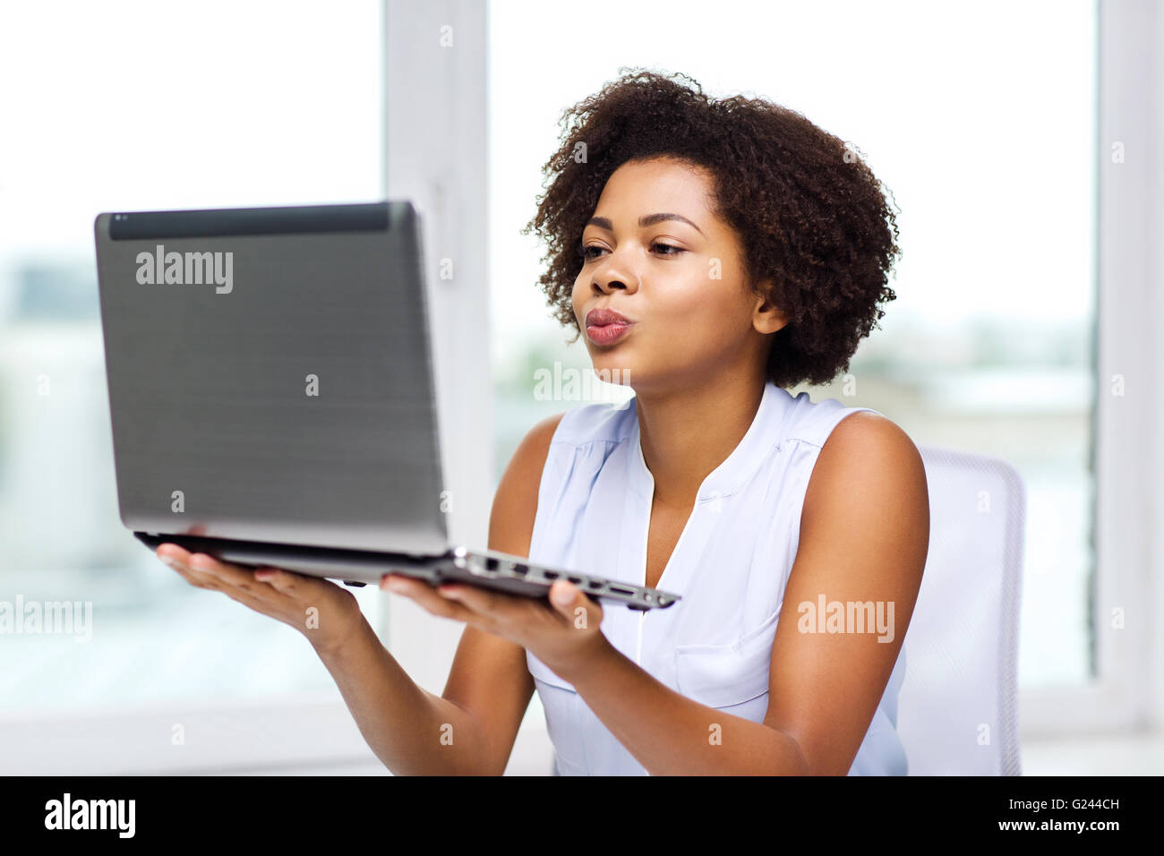 african woman sending kiss to laptop computer Stock Photo - Alamy