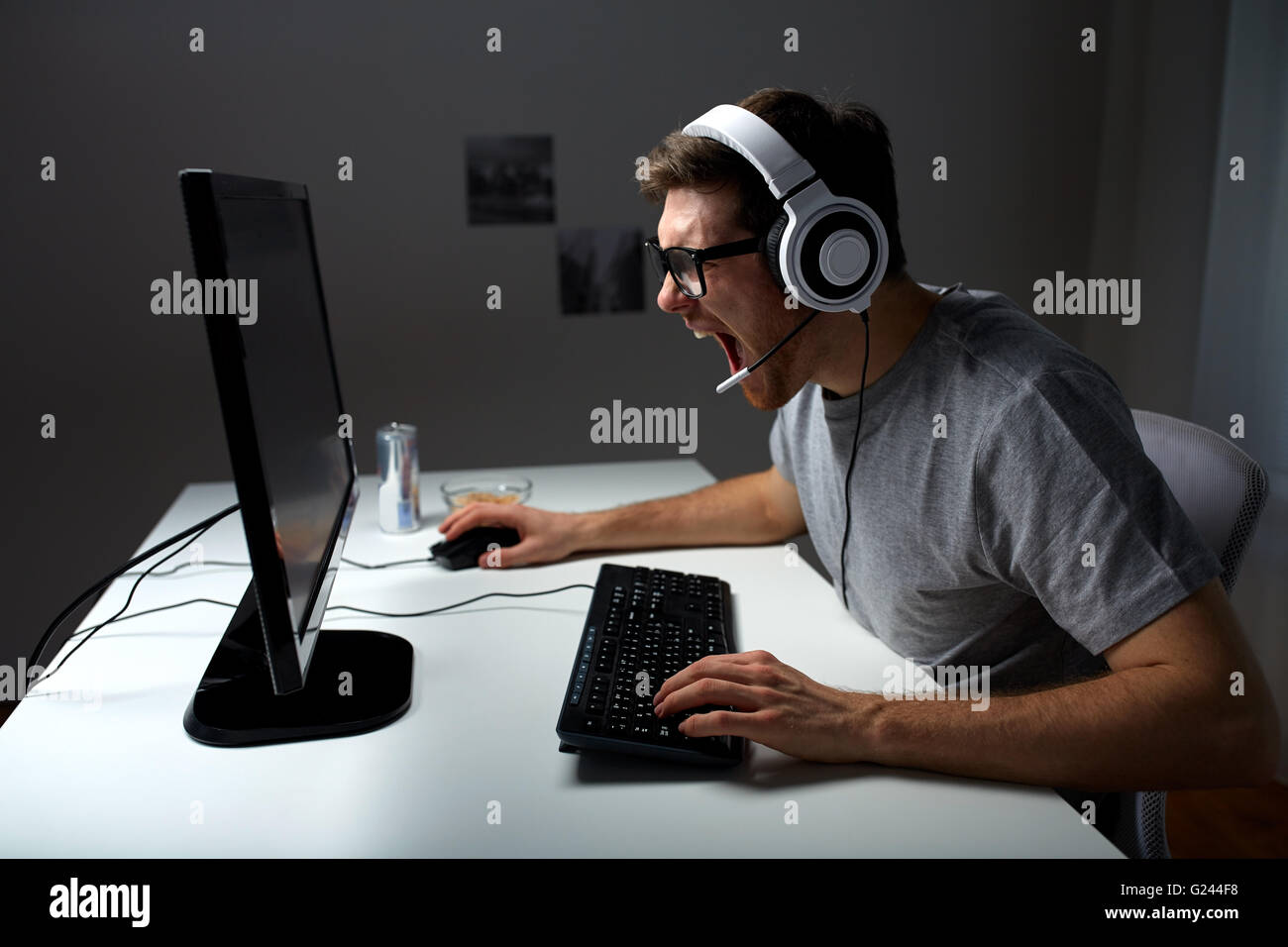 man in headset playing computer video game at home Stock Photo - Alamy
