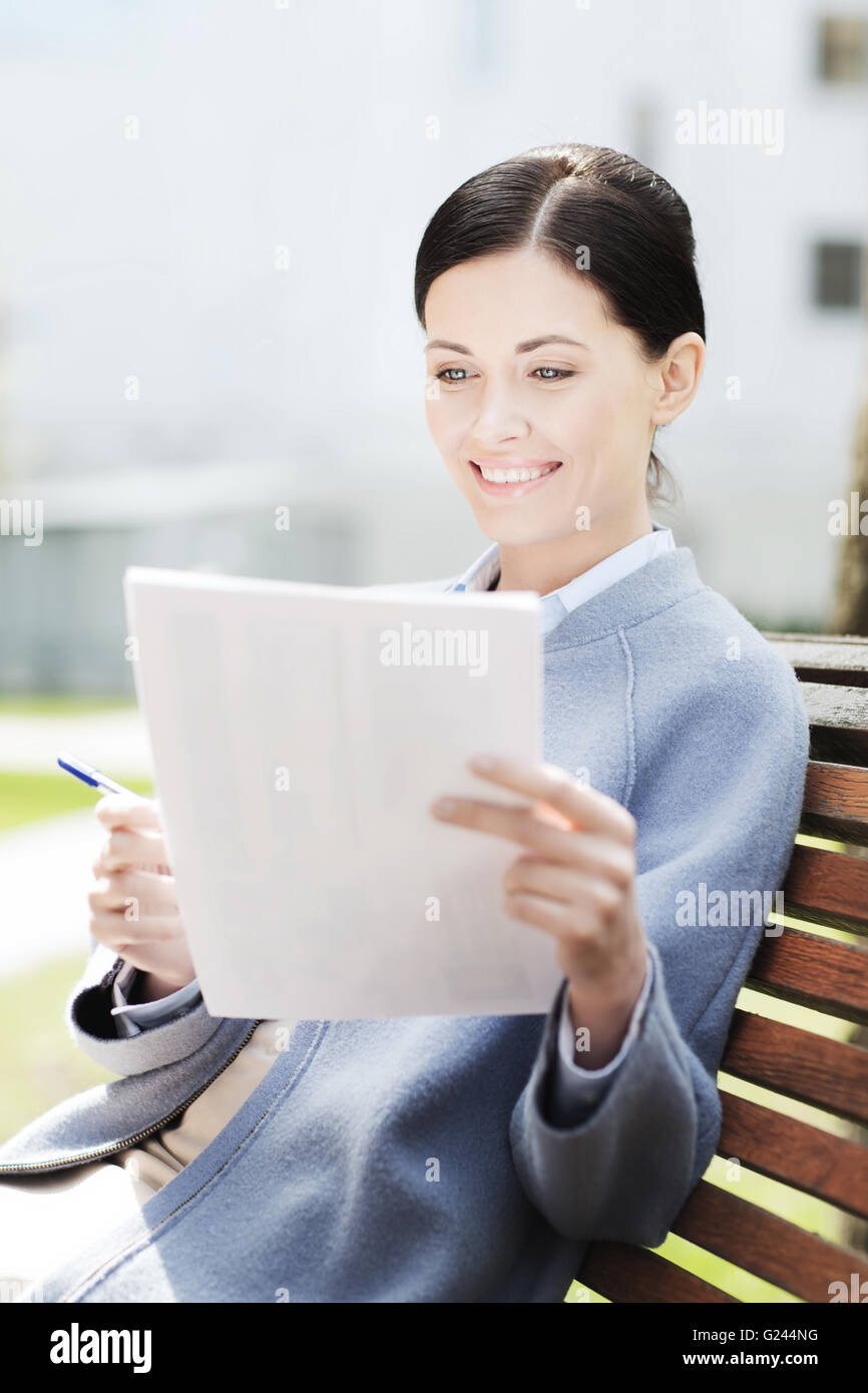 smiling businesswoman reading papers outdoors Stock Photo - Alamy