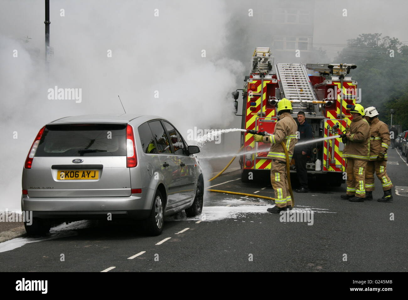 FIREFIGHTERS TACKLING A CAR FIRE WITH HOSE Stock Photo - Alamy