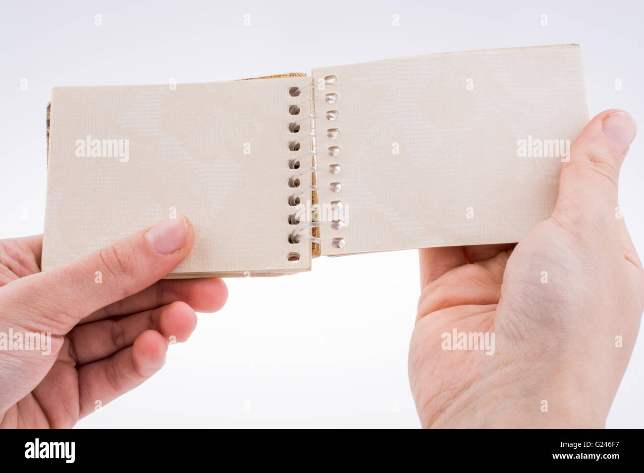 Hand holding a spiral notebook on a white background Stock Photo - Alamy