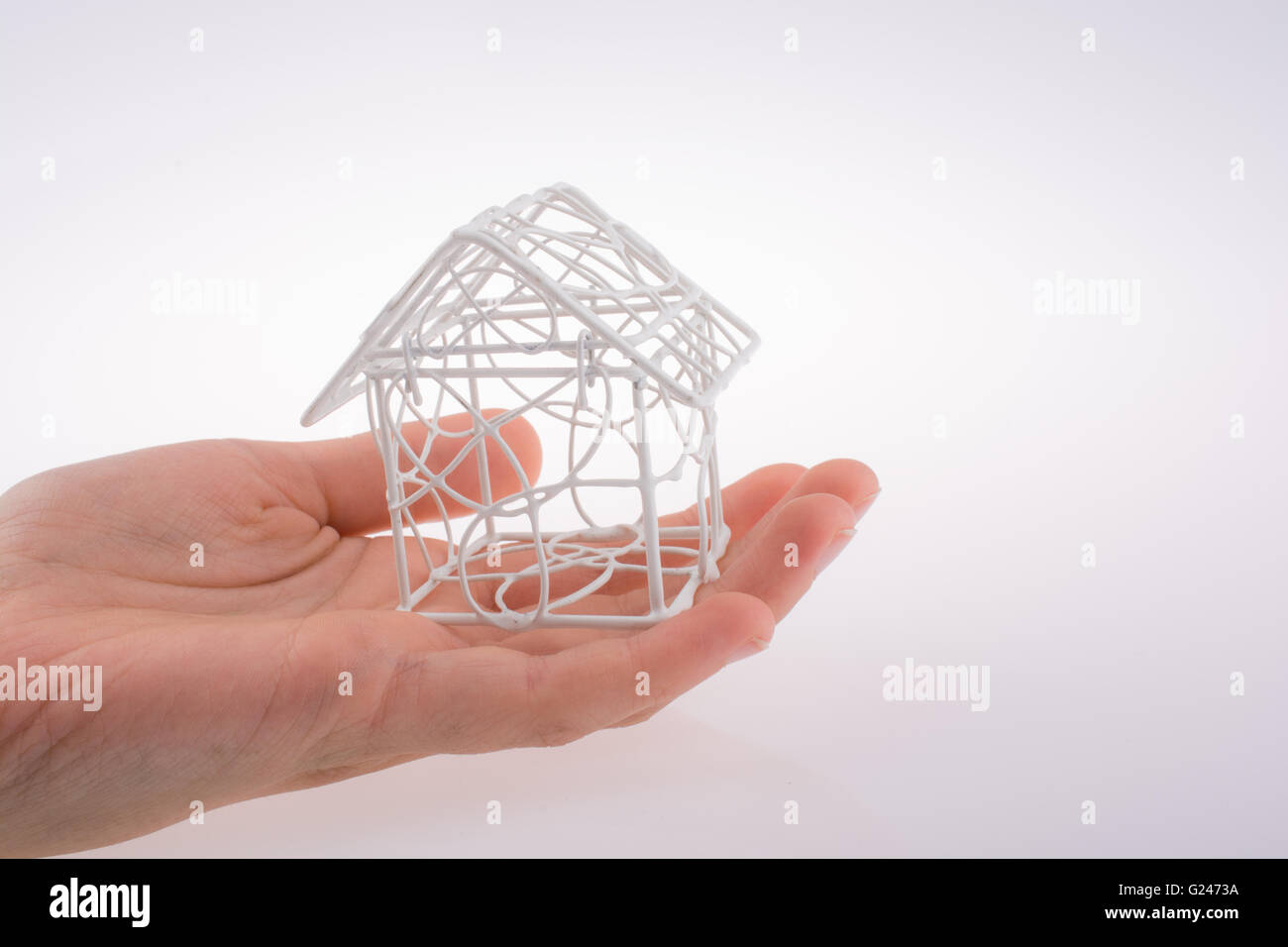 Little model house made of white metal wire in hand Stock Photo - Alamy