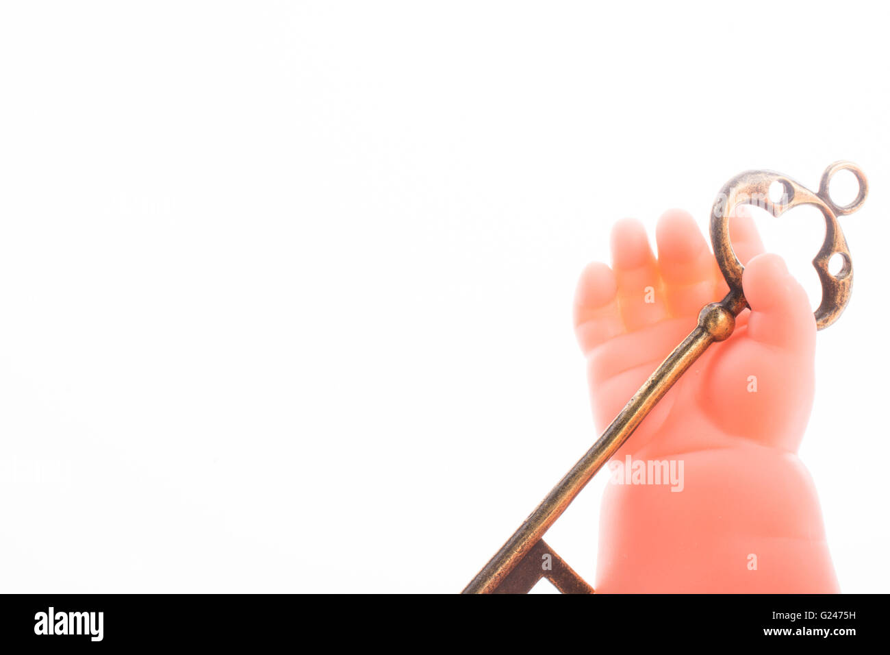 Doll holding a key on a white background Stock Photo - Alamy