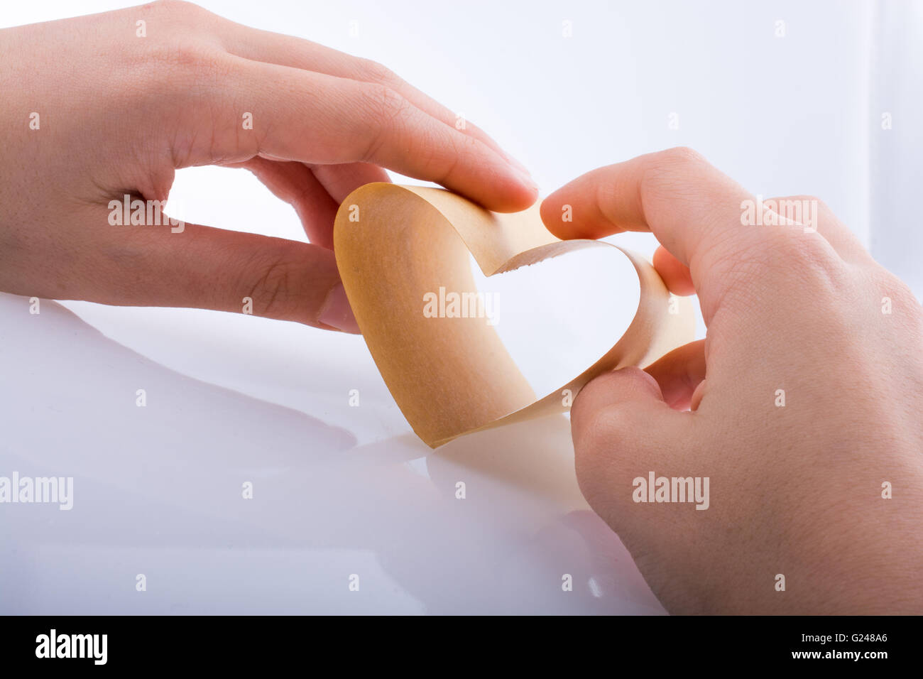 Paper forming a heart shape in hand on a white background Stock Photo ...