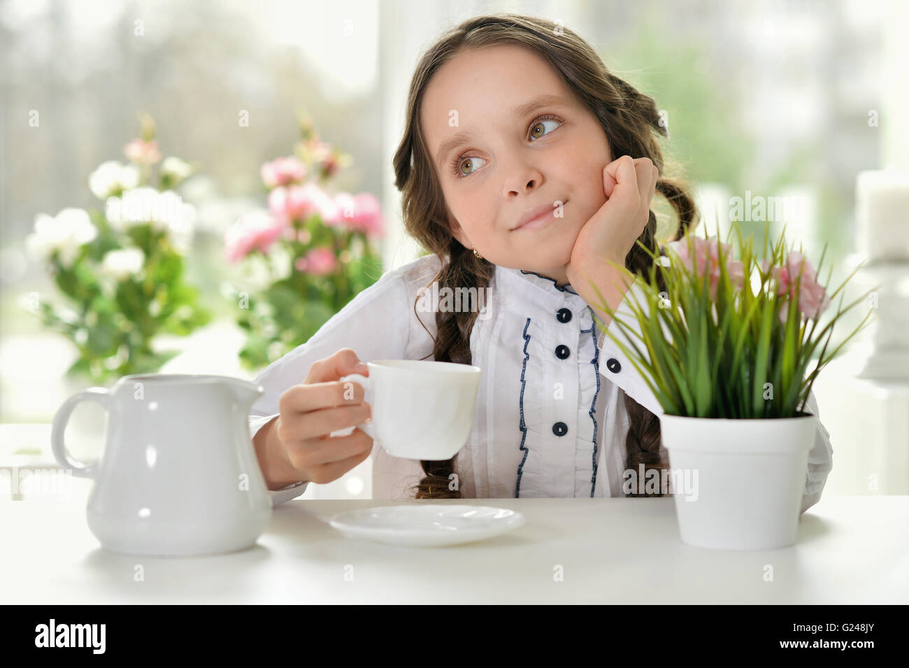 little schoolgirl drinking tea Stock Photo - Alamy