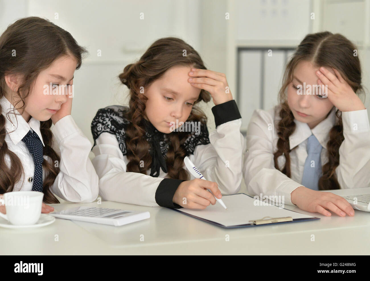 Three little girls making homework Stock Photo - Alamy