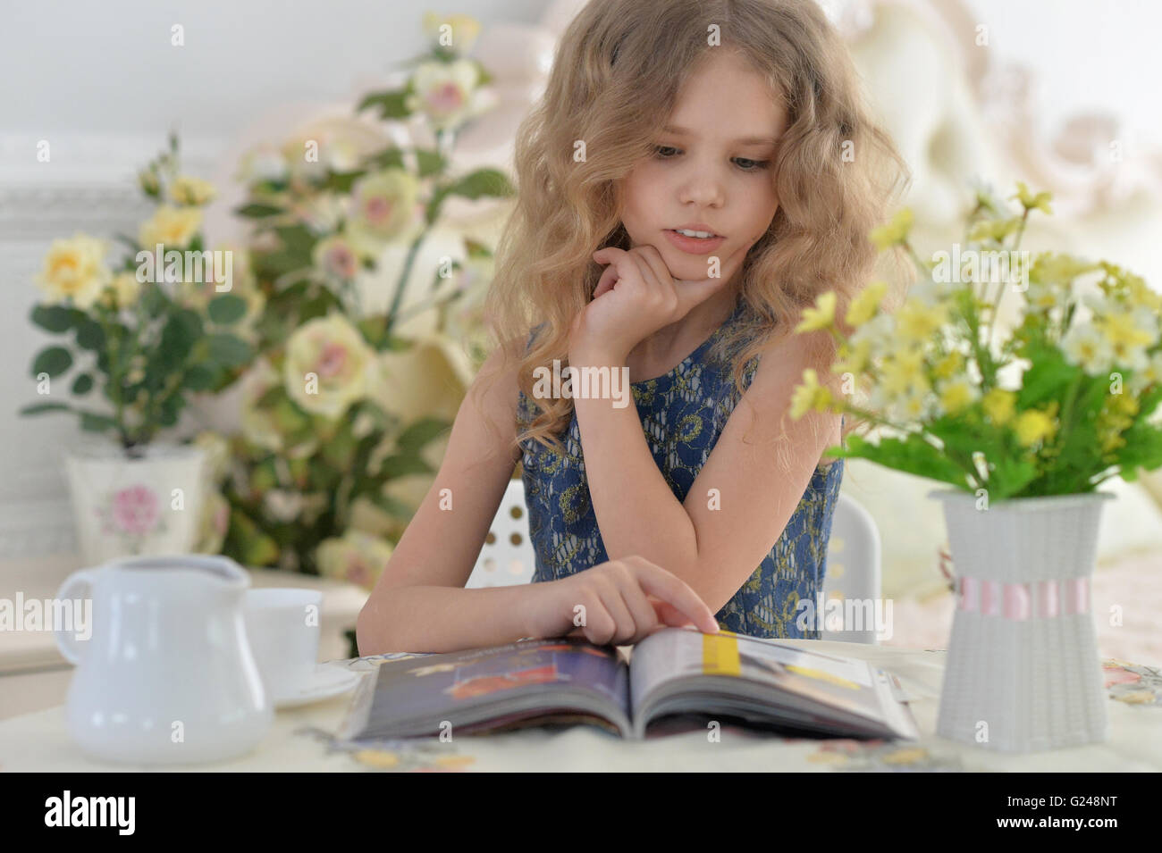 Young little girl reading a magazine Stock Photo - Alamy