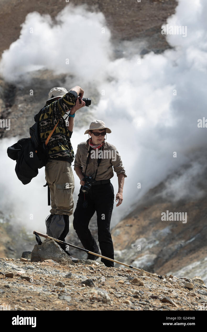 Hiking in Kamchatka - tourists photographing and looking the steaming ...