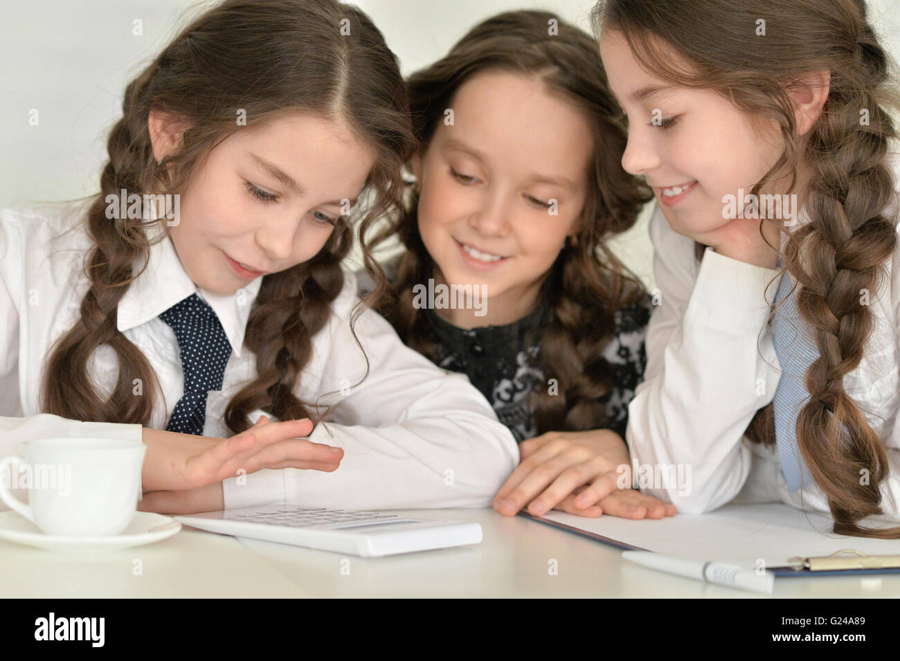 Three little girls making homework Stock Photo - Alamy