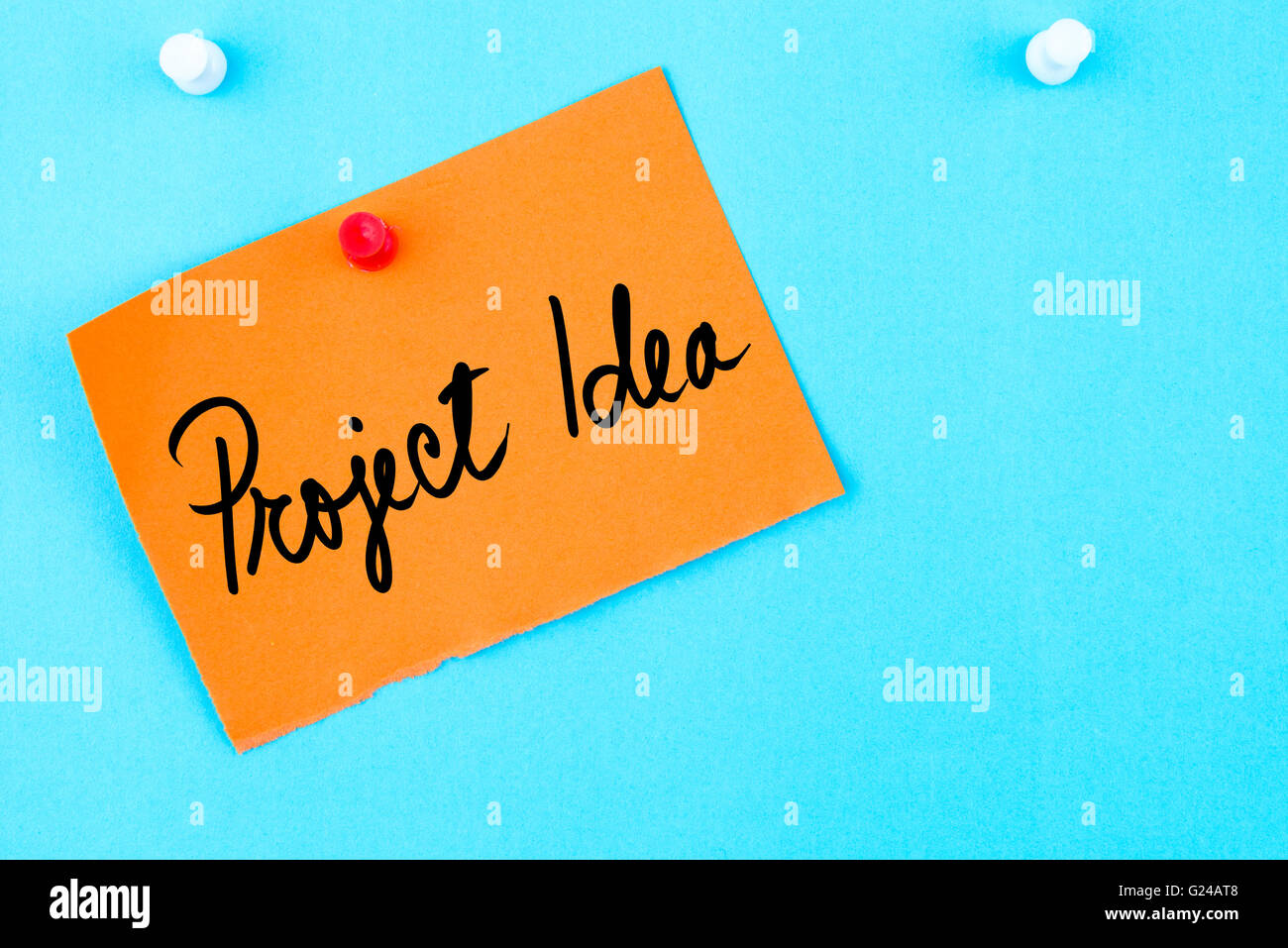 Project Idea written on orange paper note pinned on cork board with ...