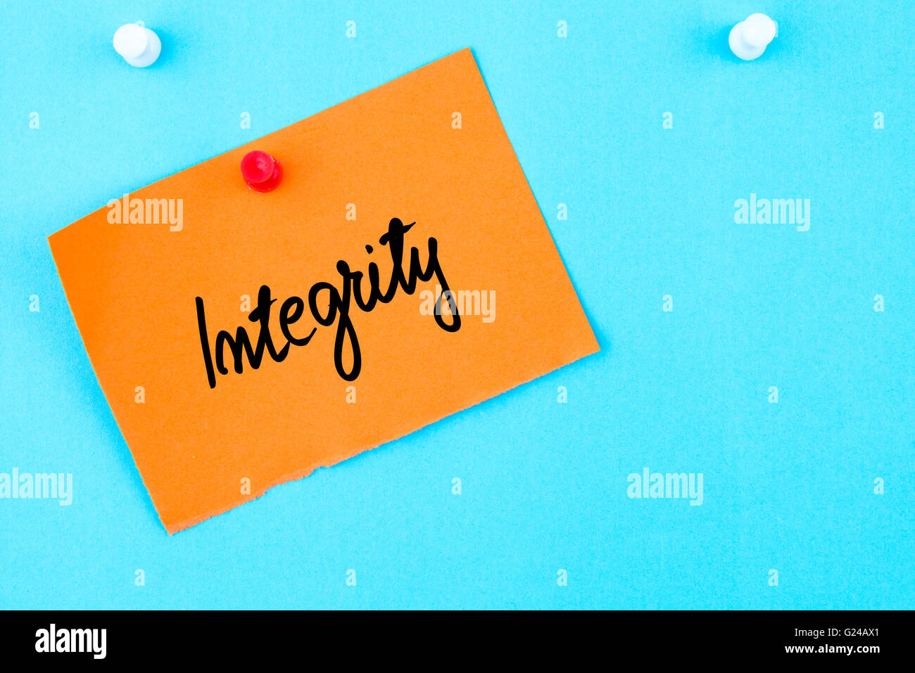 Integrity written on orange paper note pinned on cork board with white ...