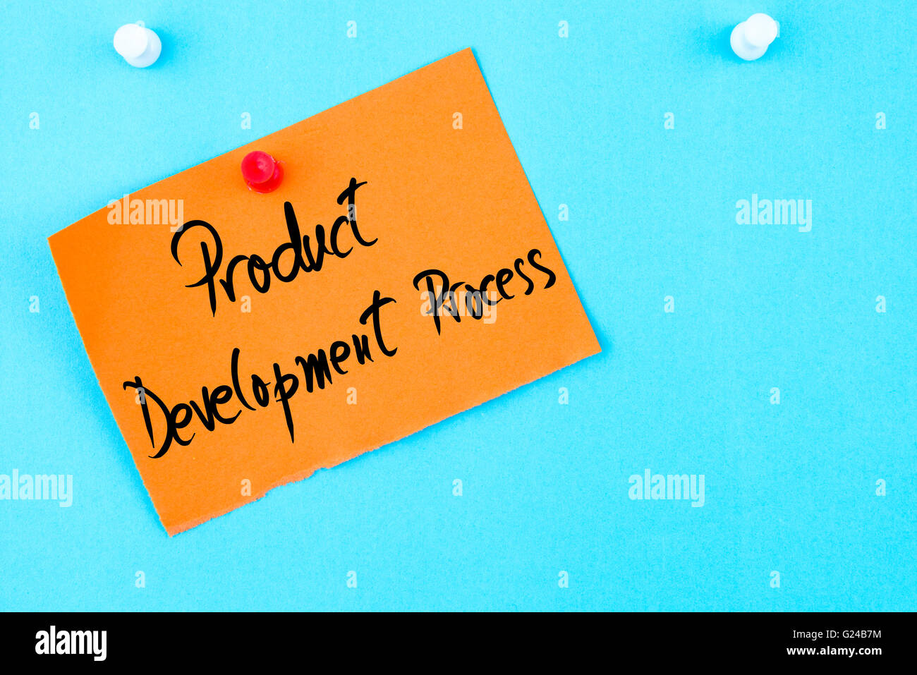 Product Development Process written on orange paper note pinned on cork ...
