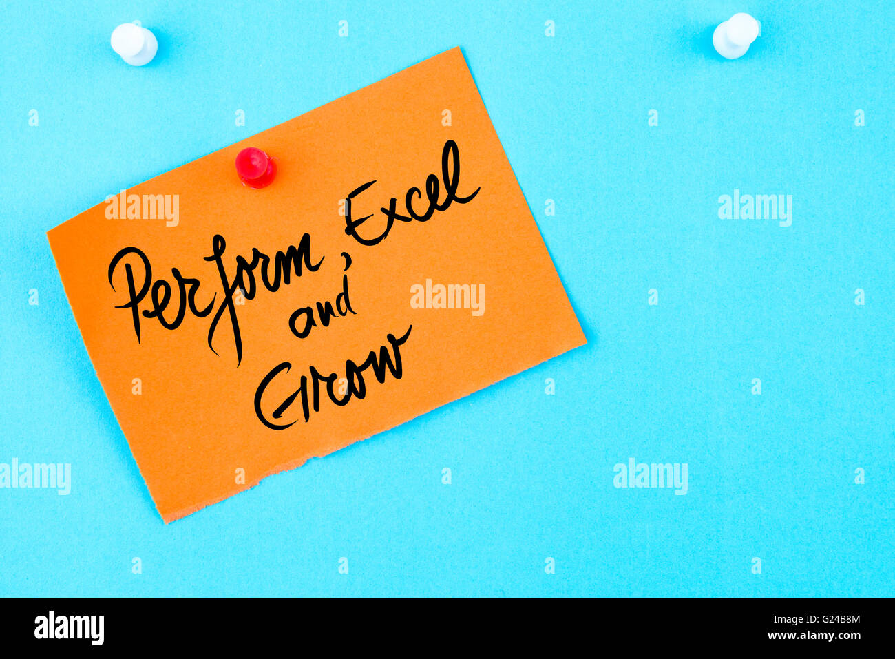 Perform, Excel and Grow written on orange paper note pinned on cork ...