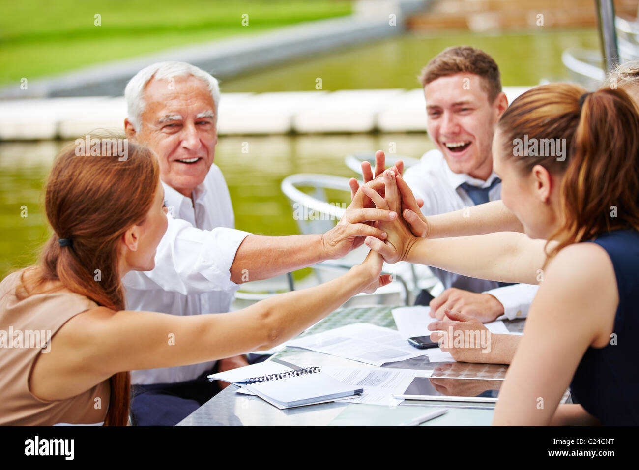 Successful business people doing high five in a meeting for motivation ...