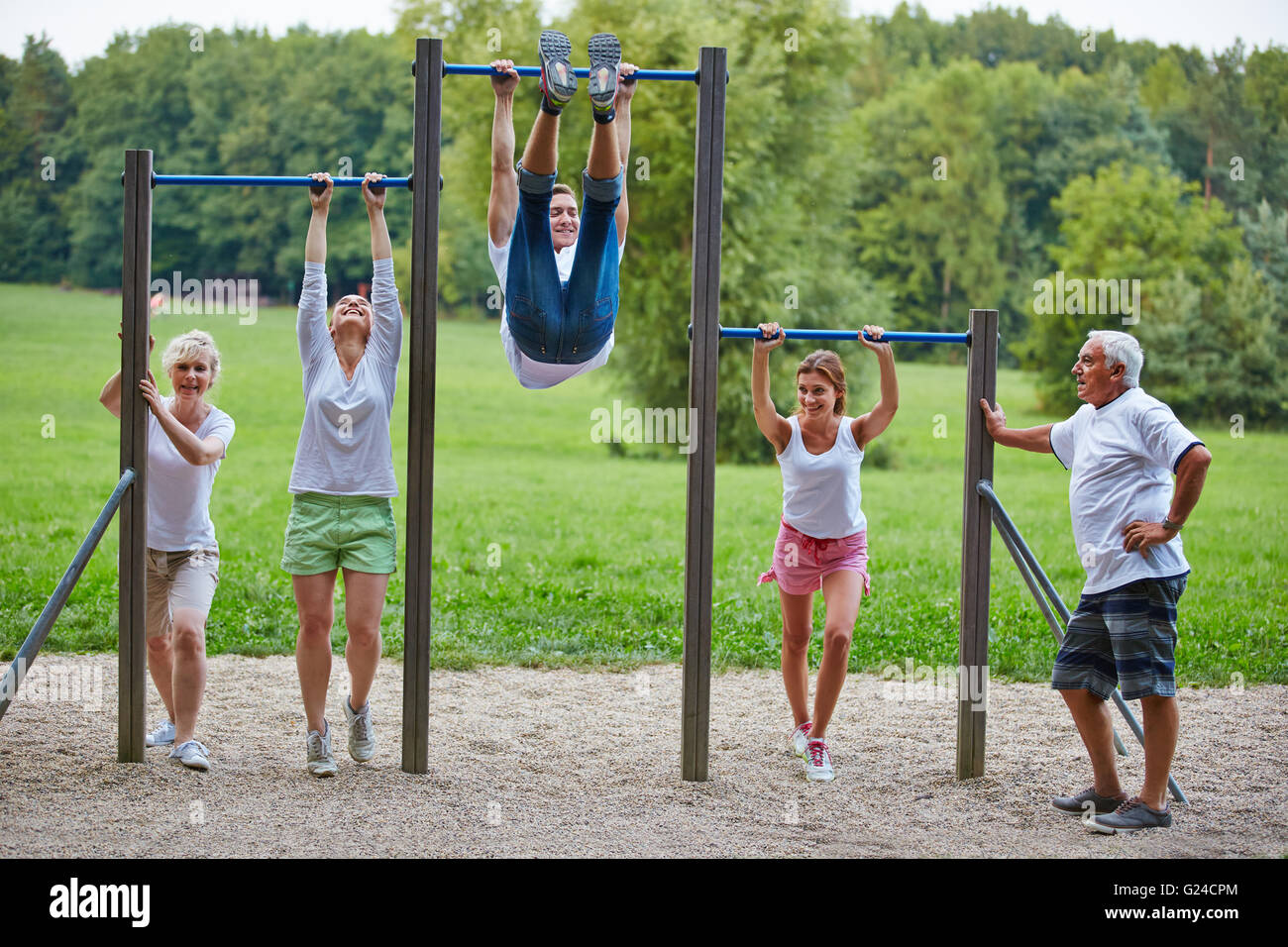 Family doing fitness training together in park at horizontal bars Stock ...