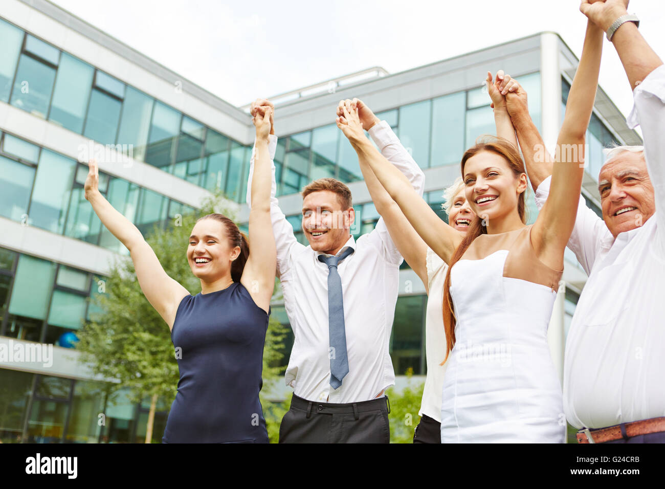 Happy cheering business team holding together the hands up Stock Photo ...