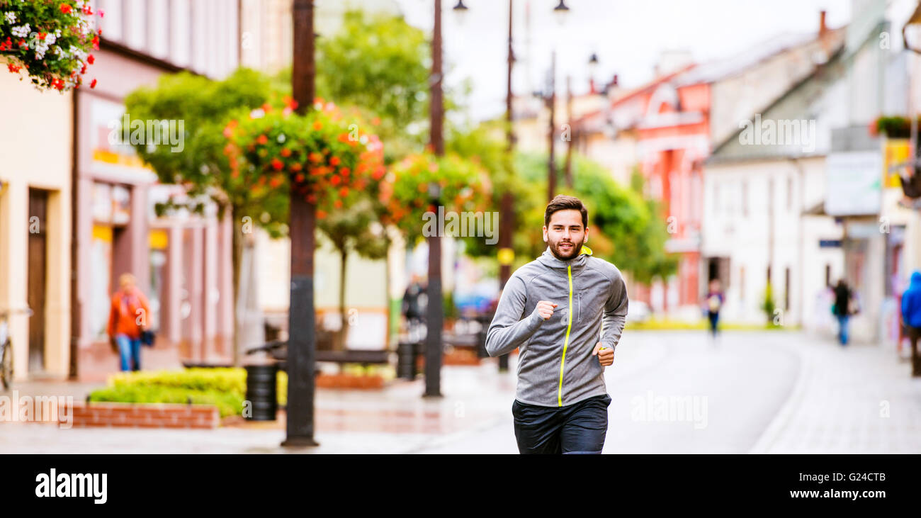 Young hipster man running in town, main street Stock Photo - Alamy