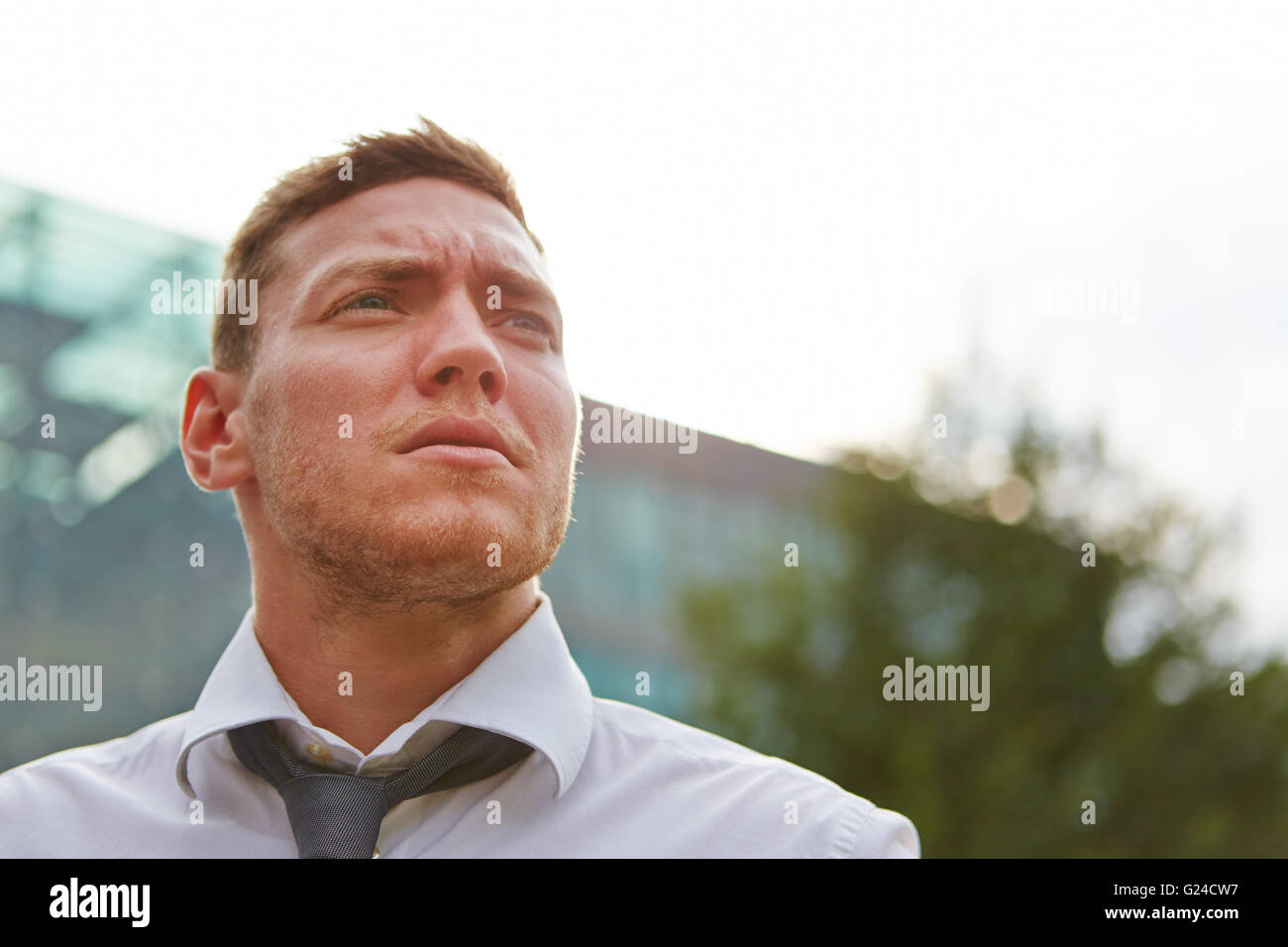 Young dynamic businessman looking seriously into the distance Stock ...