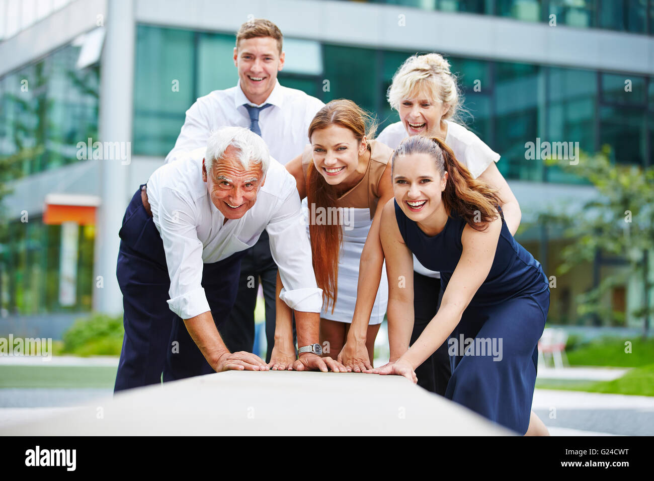 Motivated business team working together and pushing with strength ...