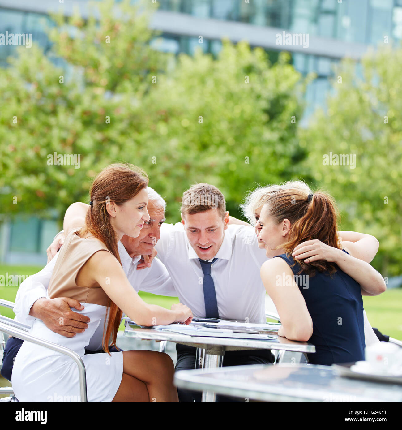 Business team hugging for motivation in a meeting outdoors Stock Photo ...