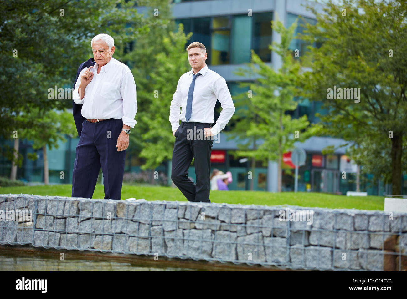 Two businessmen walking together outside the office in the city Stock ...